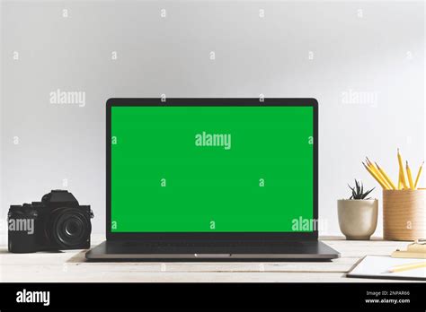 Chroma Key Green Screen Laptop And Digital Camera On Table In Front Of White Backgroud Table