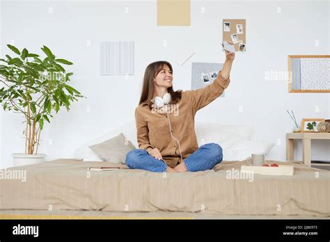 Cheerful Attractive Girl In Casual Outfit Sitting With Crossed Legs On