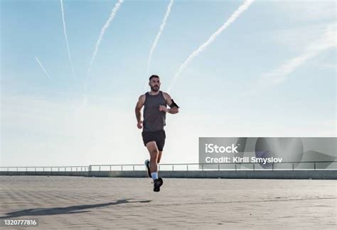Pemuda Yang Bugar Berlarian Di Tepi Laut Pelari Pria Jogging Pagipagi