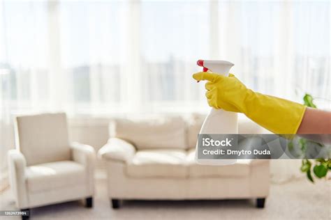 노란 보호 장갑을 끼고 흰색 스프레이 병을 들고 있는 여성의 손은 거실을 배경으로 흐릿하게 하고 공간을 복사합니다 집안일 청소 및 집안일 개념 청소 분무기를 가진 여자