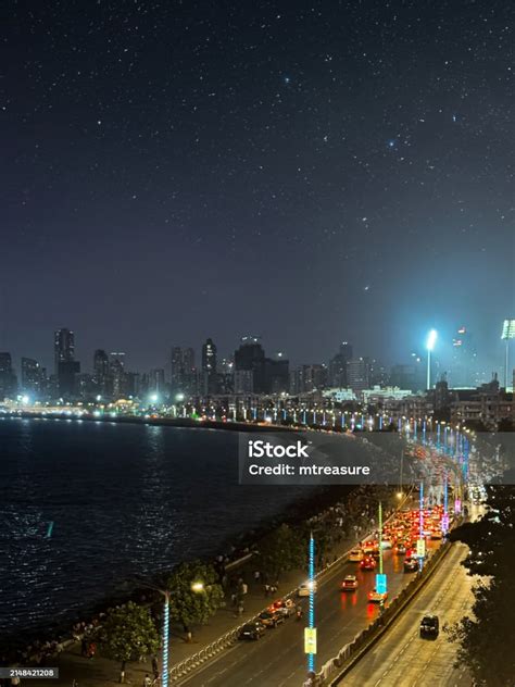 인도 뭄바이의 마린 드라이브 콘크리트 방파제 방어 C 자형 산책로 건물 및 고층 빌딩 조명 가로등 행 자동차 및 오토바이의 빨간색 후미등 및 흰색 헤드 라이트 야경의 다중