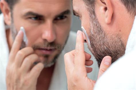 Matured Man Applying Cosmetic Cream On Face Facial Treatment Beauty