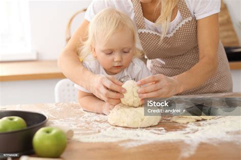 어린 소녀와 그녀의 금발 엄마 부엌에서 반죽을 반죽 하는 동안 웃 고 놀고 베이지색 앞치마에 빵 이나 피자 빵에 대 한 수 제 과자 쿠키 2명에 대한 스톡 사진 및 기타