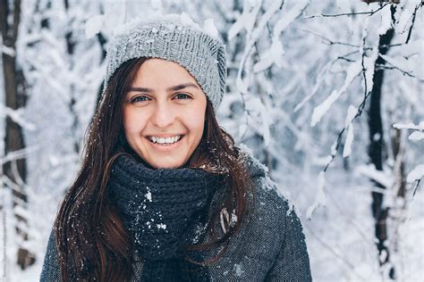Portrait Of Happy Woman Wearing Knit Hat In Snowy Field By Stocksy