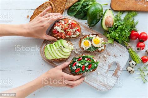 맛있고 맛 있는 브루 쉐 타 토마토 시금치 아보카도 Feta 빨강 칠리 페 퍼와 블루 치즈 마이크로 녹색 참 깨 씨 및 아마 건강 한 먹는 개념 구운 식품에 대한 스톡 사진