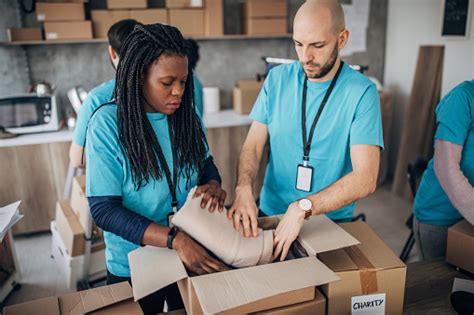 자선 푸드 뱅크에 기부 상자를 포장하는 다양한 자원 봉사자 Giving Tuesday에 대한 스톡 사진 및 기타 이미지 Giving Tuesday 공동체 기부함
