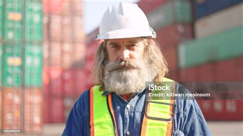 안전모와 안전 조끼를 착용한 전문 엔지니어 또는 관리자 또는 작업자의 초상화는 자신감과 리더십을 가지고 적재 컨테이너 야드에서