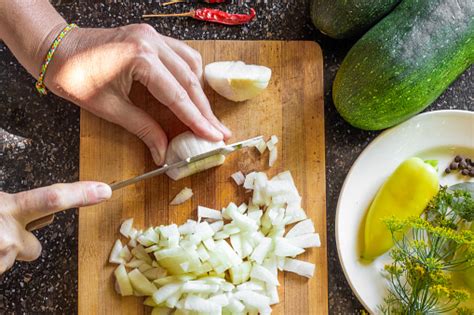 한 여성이 겨울 야채 샐러드를 준비하기 위해 나무 판자에 양파를 자릅니다 칼을 가진 여성의 손 평평한 누워 건강한 생활방식에