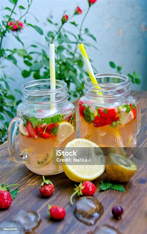 얼굴 수 제 레모네이드 레몬과 민트 딸기 키 위 나무 테이블에 흐리게 하는 과일과 얼음의 조각 누워 푸른 정원에서 배경 0명에 대한 스톡 사진 및 기타 이미지 Istock