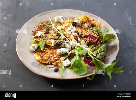 Carrot Parsnip Chili And Coriander Rosti With Organic Salad Goats Cheese Sultanas And Flaked