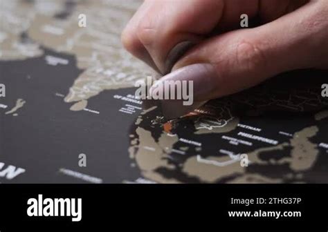 scratching thailand country on the surface of scratch world map woman