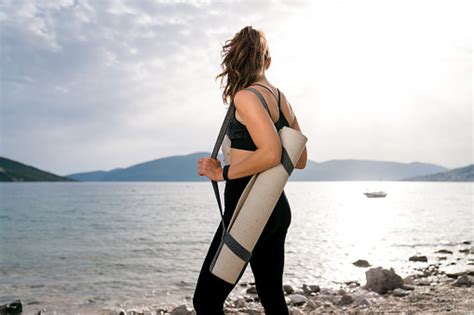 바다 해변에서 스포츠와 피트니스 요가 매트를 가진 여자 자연에서 운동을 준비하는 소녀 건강한 생활 방식 아침 운동 여성 건강과 힘 자기 관리 야외 활동의 개념 여름에 대한