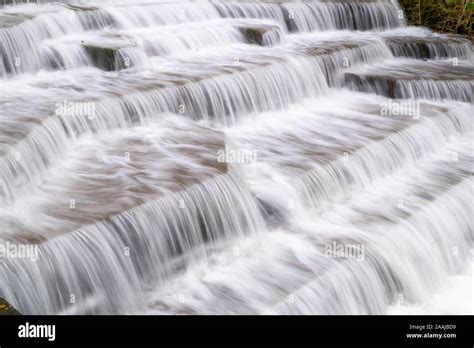 Water Cascading Over Weir Steps On Canal Slipway Showing Blur Blurred Motion And Freeze Frame Of