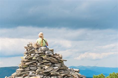 Young Woman Sitting On A Top Of Mountain Young Woman Sitting On A Top