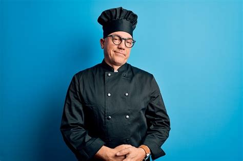 중년 잘 생긴 회색 머리 요리사 남자 함께 손으로 밥솥 유니폼과 모자를 입고 편안하고 쾌활한 미소 손가락을 교차 성공과 낙관적 긍정적인 감정 표현에 대한 스톡 사진 및 기타