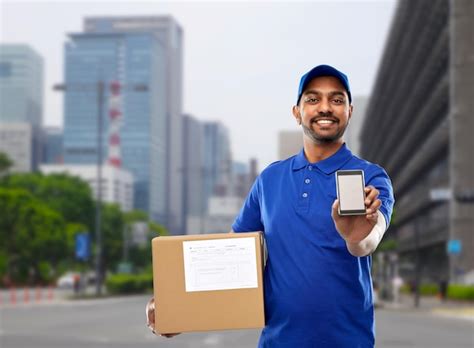 Premium Photo Indian Delivery Man With Smartphone And Parcel Box