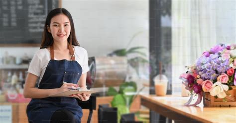 여성 커피숍 주인이 메모장을 들고 카메라를 향해 웃고 있다 사진 Unsplash의 태국 이미지