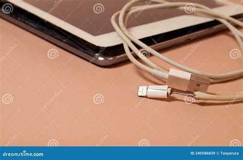 A Broken Tablet With A Swollen Battery And A Dirty Screen And A Bare USB Wire Stock Image