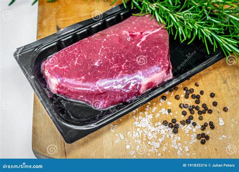 Beef Steak In Airtight Skin Packaging And Spices On Wooden Chopping