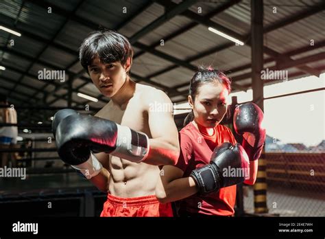Asian Female And Male Boxers Stand In Boxing Gloves With Back To Back In The Boxing Ring Stock