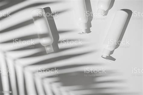 브랜딩 및 라벨을 위한 플라스틱 포장 화장품 모형 흰색 깨끗한 화장품 병 흰색 배경에 열대 야자 잎 그림자가 평평한 평면도를 놓습니다 스파 샴푸 로션 모이스처라이저 병에