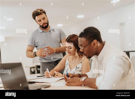 A Diverse Group Of Employees Collaborating And Working In A Modern Office Analyzing Statistics
