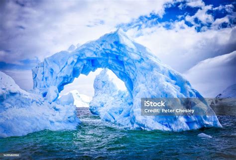 An Iceberg Of Blue Ice In Antarctica With An Interesting Hole Arch