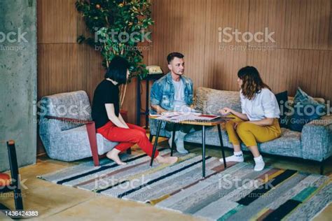 현대적인 아파트 인테리어의 전문 디자이너 회의 캐주얼 한 옷을 입은 남녀 동료가 생산적인 개발을위한 브레인 스토밍 과정을 가진 공통 프로젝트에 협력합니다 25 29세에 대한