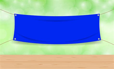 녹색 보케 배경과 나무 판자 테이블에 비닐 빈 파란색 배너 광고 스탠드 매달려 에 대한 빈 섬유 직물을 조롱 복사 공간 프리젠 테이션 광고를위한 실내 야외 직물 비닐 배경