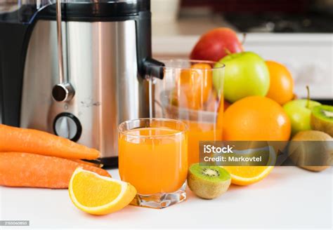유리잔에 담긴 과일과 채소의 신선한 주스와 주방의 테이블에 현대적인 과즙 짜는기구 집에서 맛있고 건강한 주스 선택적 초점