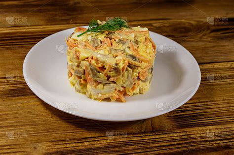 美味的沙拉配鸡胸肉烤蘑菇胡萝卜磨碎的奶酪鸡蛋和蛋黄酱放在木桌上