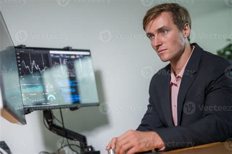 Professional Man Analyzing Data On A Computer Screen In A Modern Office Setting During The Day