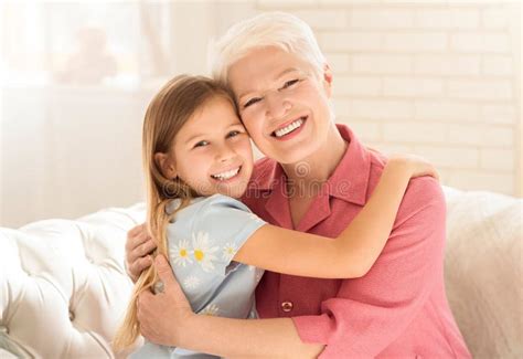 Happy Granny With Granddaughter Hugging On Sofa At Home Stock Image Image Of Embrace Love