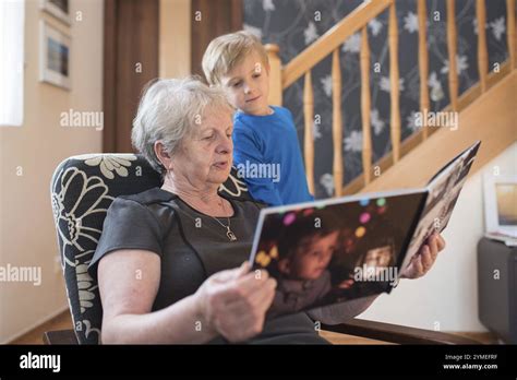 Grandmother And Grandson Watching Photo Album With The Grandson
