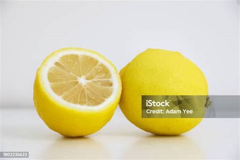 흰색 배경에 질감과 단면 패턴을 보여주는 전체 레몬과 반쯤 썬 레몬 레몬은 신맛 육즙 맛과 건강상의 이점으로 알려진 감귤류 과일입니다 0명에 대한 스톡 사진 및 기타 이미지