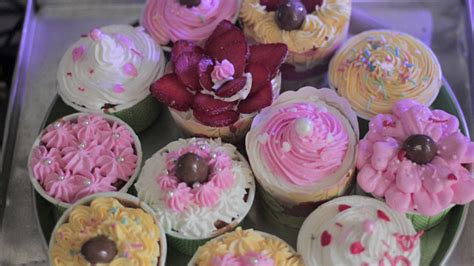 분홍색과 흰색 프로스팅 식용 진주 초콜릿 장식 신선한 딸기 조각이 소용돌이치며 아름답게 장식된 컵케이크 모음입니다 축제와 우아한 디저트 디스플레이 0명에 대한 스톡 사진 및