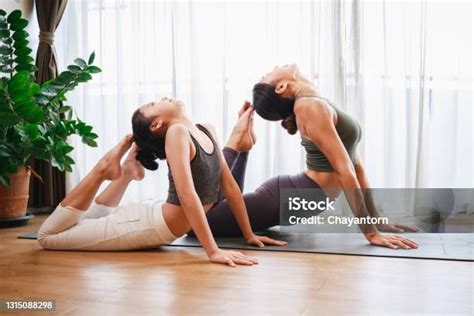 아시아 젊은 어머니는 집에서 거실에서 요가 매트에 요가 포즈와 운동에 그녀의 딸을 가르치고 10 11세에 대한 스톡 사진 및