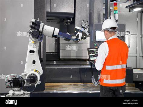 Maintenance Engineer Using Laptop Computer Control Automatic Robotic Hand With Cnc Machine In
