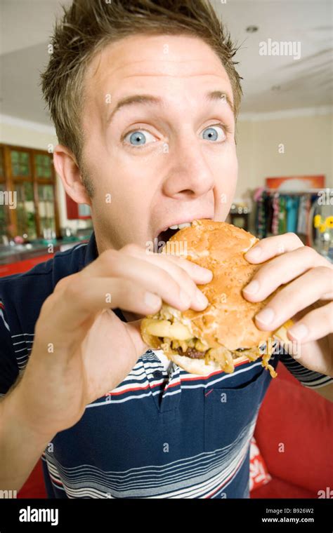 South African Teen Culture Young Man Taking A Bite Of A Burger Stock