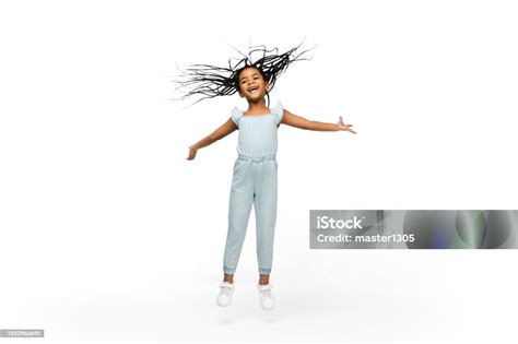 화이트 스튜디오 배경에 고립 된 행복한 긴 머리 갈색 머리 어린 소녀 행복하고 쾌활하며 성실한 것처럼 보입니다 복사 공간을 참조하십시오 어린 시절 교육 감정 개념 점프에