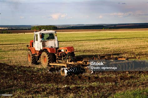 화창한 봄날에 트랙터 쟁기와 하로우가 큰 들판에 착륙합니다 작물을 심기위한 토양을 준비 디스크 쟁기와 트랙터와 토양을 쟁기 계절에 대한 스톡 사진 및 기타 이미지 Istock