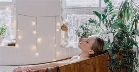 눈을 감고 욕조에 누워 꿈꾸는 젊은 성인 여성의 측면 모습 집에서 쉬고 스파 절차를 즐기고 있다 사진 Unsplash의 욕조 이미지