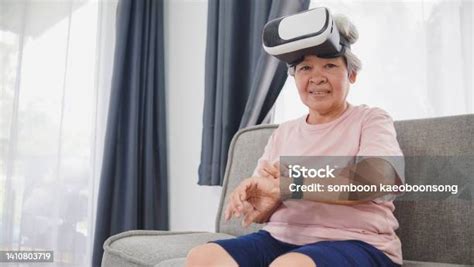 가상 현실 기술 개념 스마트 시계를 누르고 Vr 안경을 착용하고 집에있는 거실에서 카메라를 보는 노인 아시아 여성 가상현실에 대한 스톡 사진 및 기타 이미지 Istock