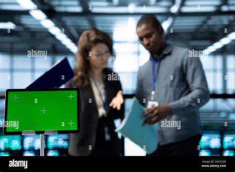 Close Up Of Green Screen Tablet In Front Of Employees Overseeing Server