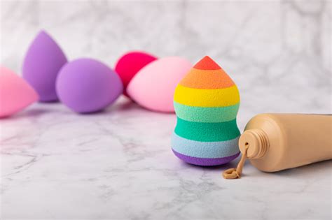 뷰티 블렌더와 파운데이션 크림은 흰색 대리석 배경에 있다 메이크업 화장품 스폰지 메이크업 제품 아름다움 개념입니다 텍스트를 위한 위치입니다 복사를 위한 공간입니다 플랫 레이