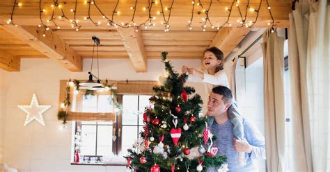 어린 딸에게 함께 크리스마스 트리를 장식하는 피기백을 주는 젊은 아버지 사진 Unsplash의 나무 이미지