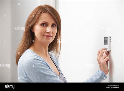 Woman Adjusting Digital Central Heating Thermostat Control Stock Photo Alamy