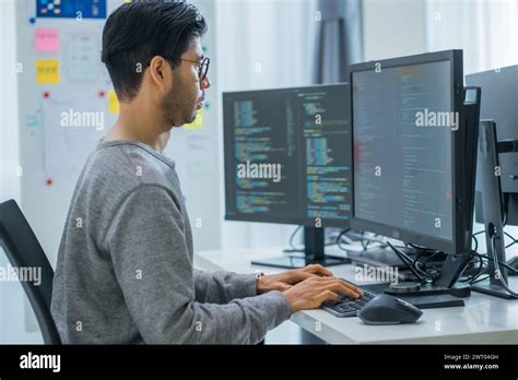 Asian Prompt Engineer Developer Coding App With Software Data Sitting In Front Of Computer