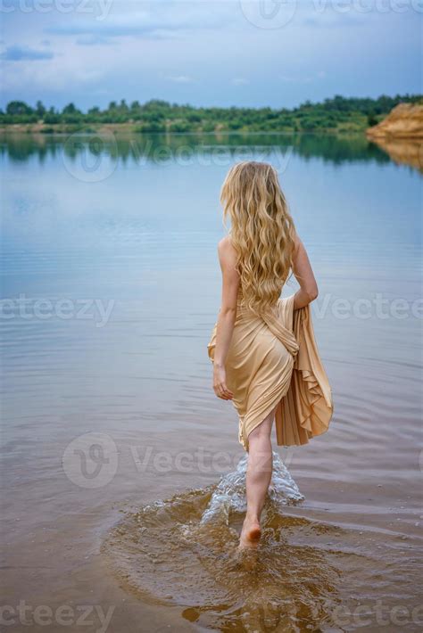 Eine Schöne Schlanke Junge Frau In Einem Langen Kleid Steht Im Wasser