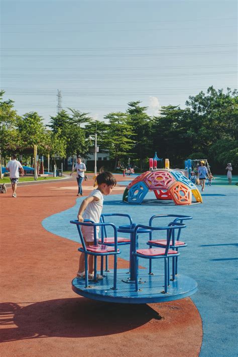 낮 동안 수역 근처의 파란색 금속 의자에 앉아 있는 흰색 티셔츠를 입은 여자 사진 Unsplash의 무료 운동장 이미지